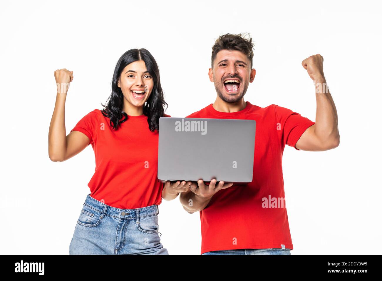 Portrait of a satisfied happy couple holding laptop computer while ...