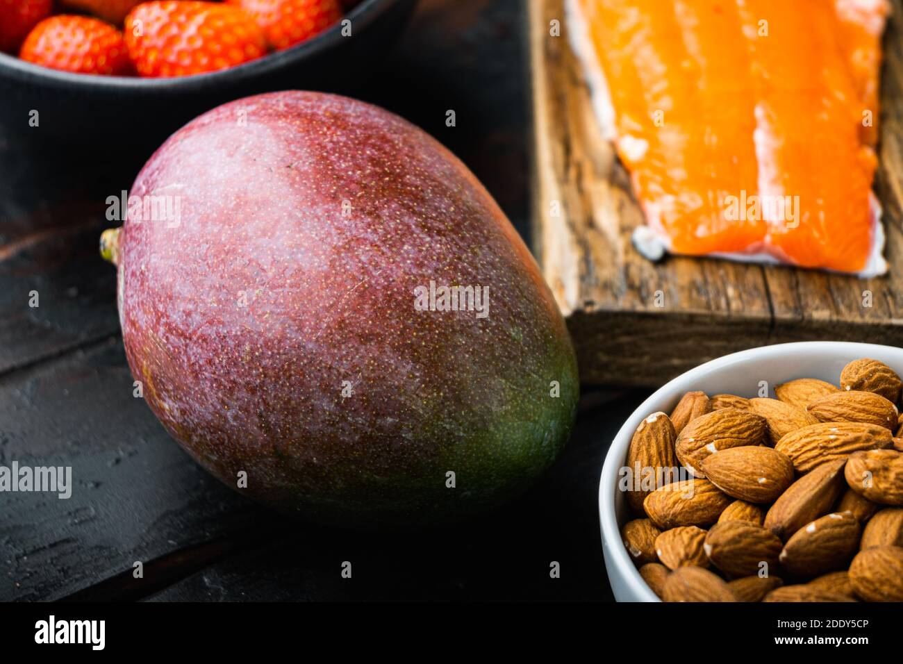 Whole exotic mango on dark wooden background Stock Photo - Alamy
