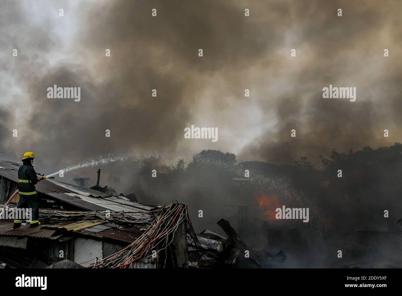 Manila, Philippines. 27th Nov, 2020. A firefighter tries to put out a ...