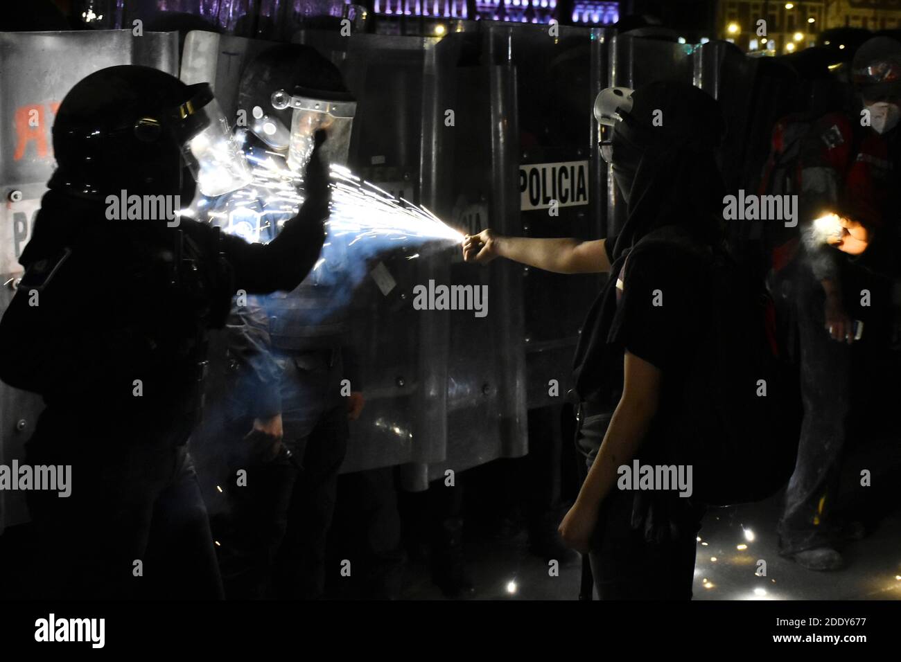 MEXICO CITY, MEXICO - NOVEMBER 25: A woman confronts a riot police line ...