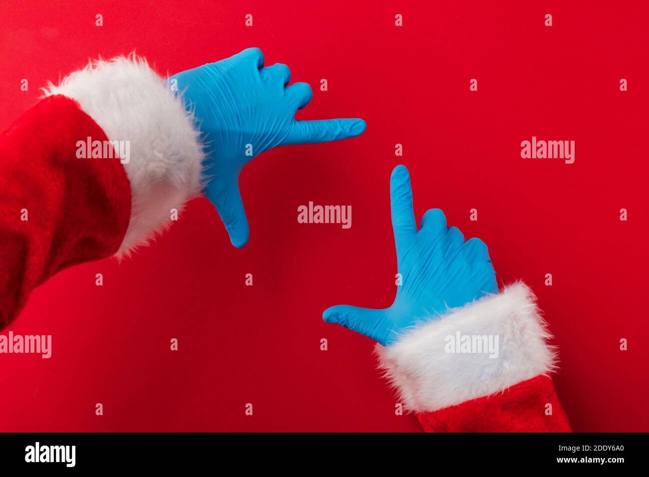 Santa hands wearing blue PPE protective gloves making frame with hands ...
