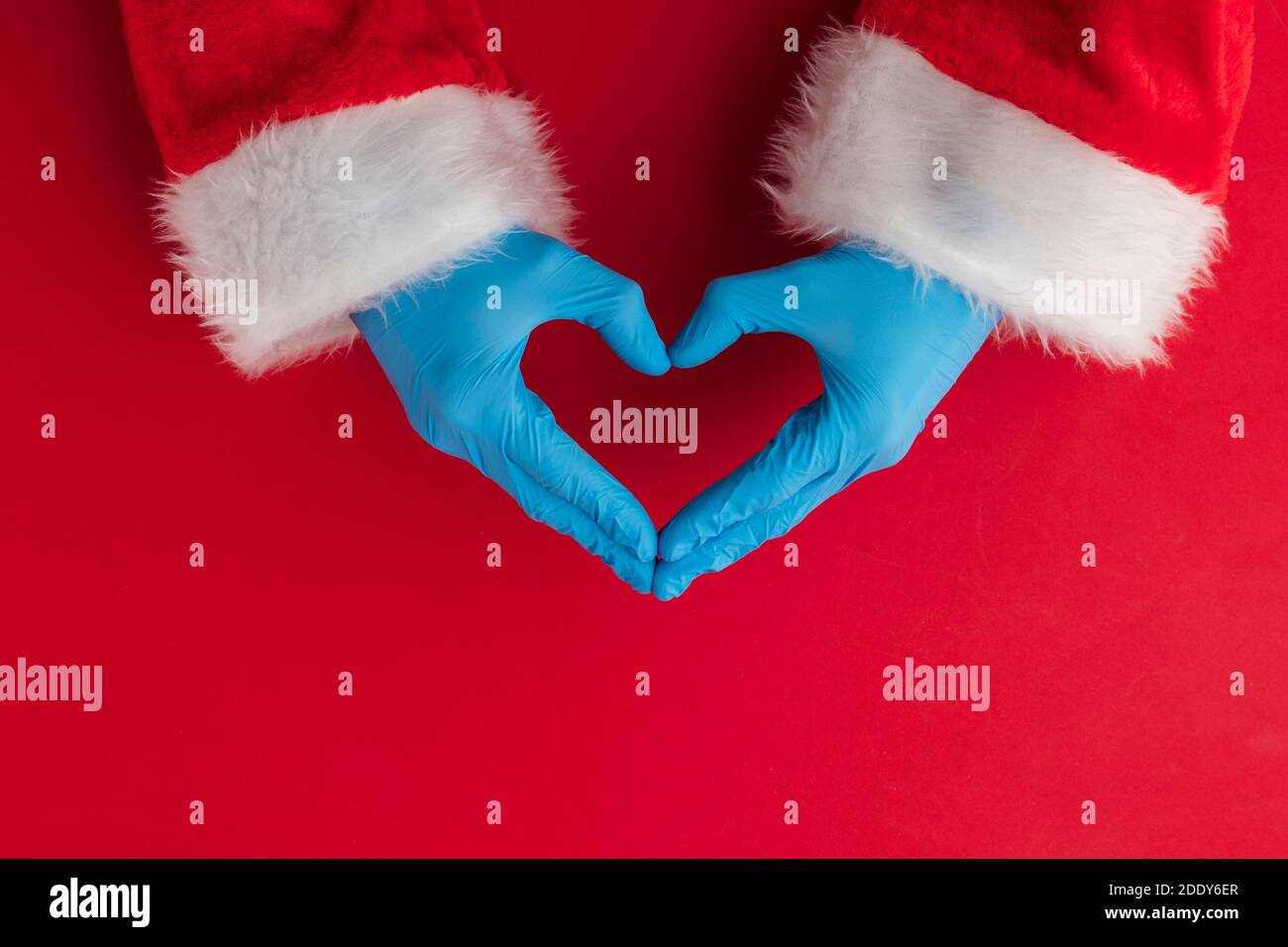 Santa hands wearing blue PPE protective gloves make love heart sign ...