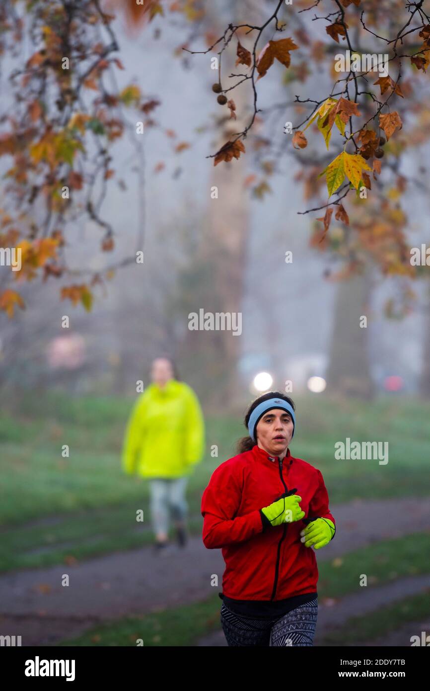 London, UK. 27th Nov, 2020. On a misty morning, Clapham Common is busy ...
