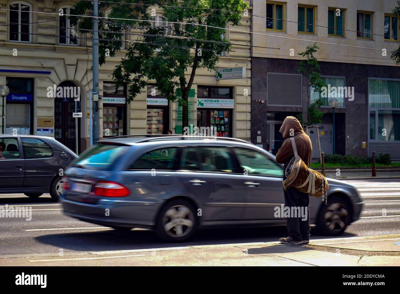 Standing, waiting near the street. The man standing against moving city ...