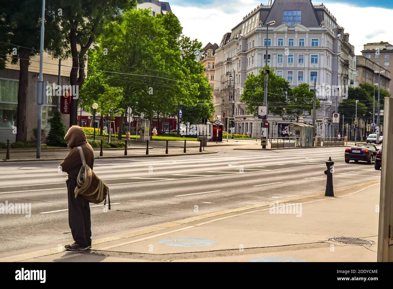 Standing, waiting near the street. The man standing against moving city ...