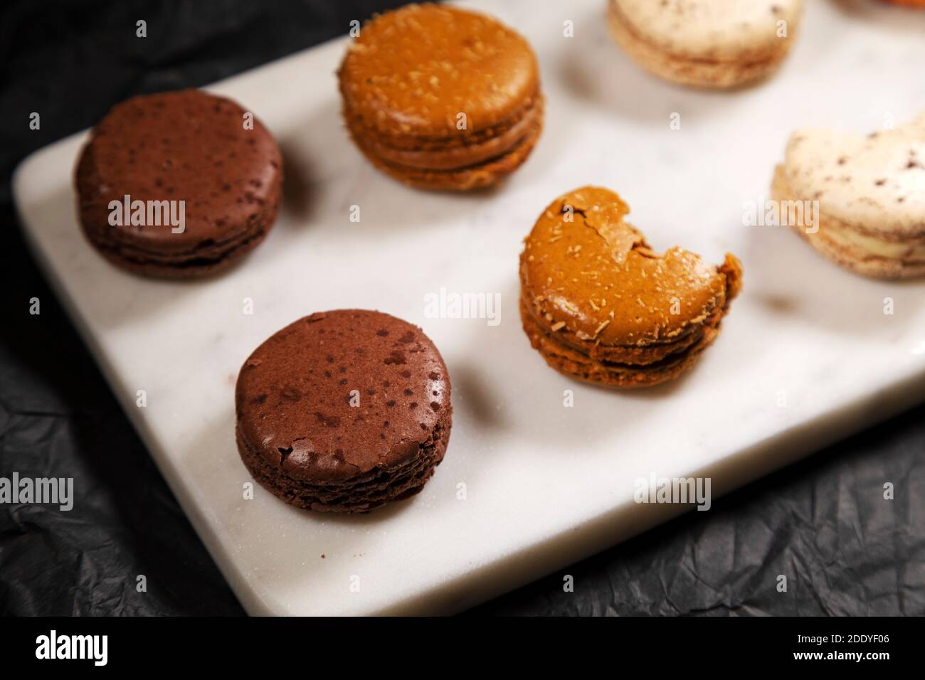 Vegan macarons on a marble platter. The French-style macaroons are made ...