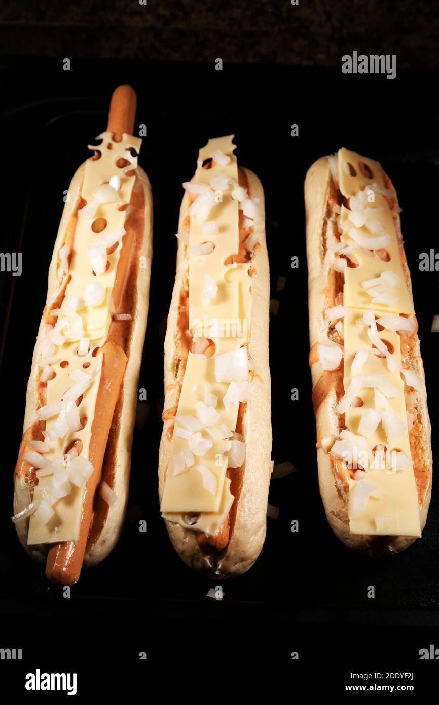 Spanish hot dogs ready for the oven. Hot dogs have been placed in a ...