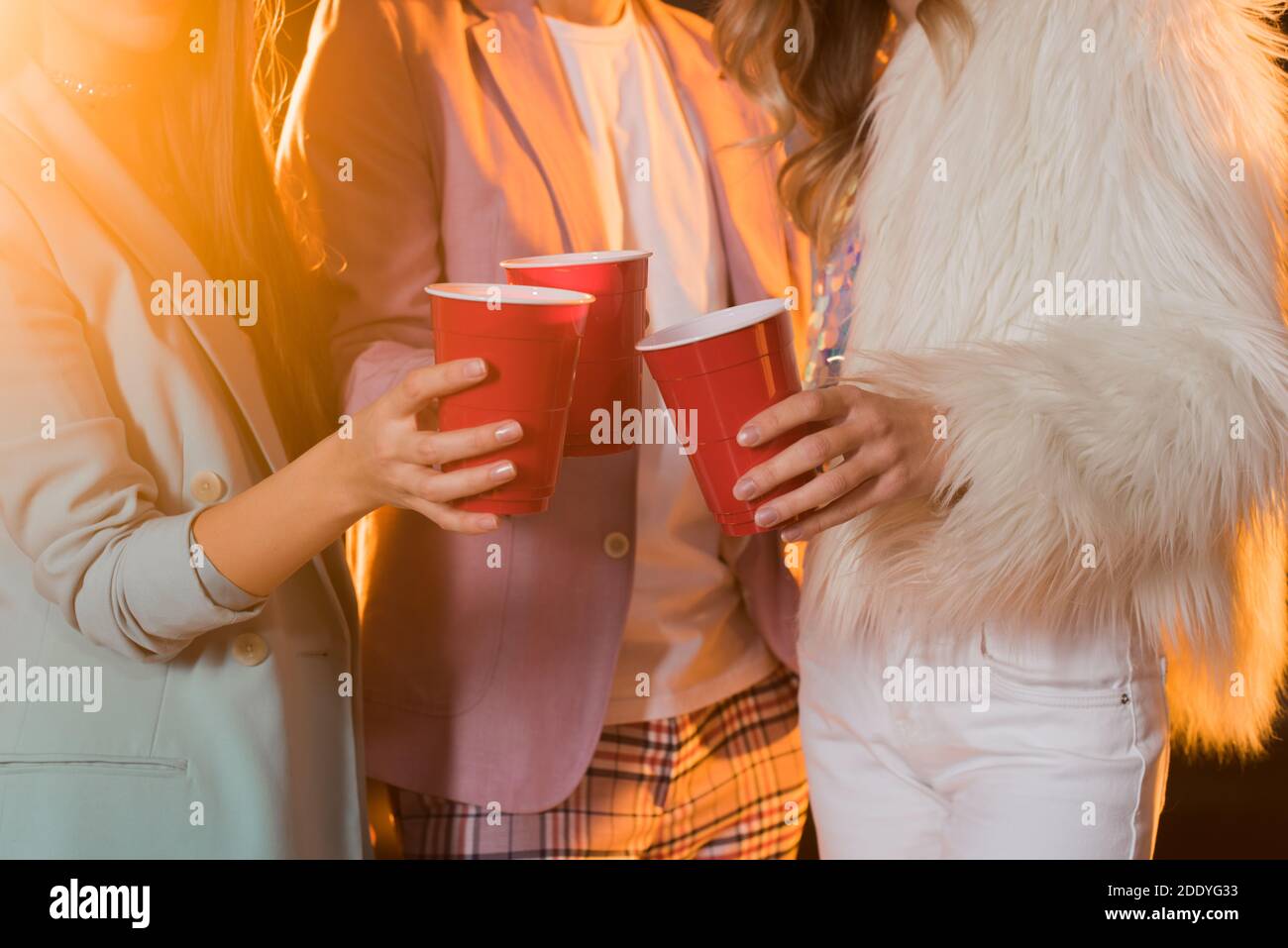 cropped view of man and women toasting plastic cups during party on ...