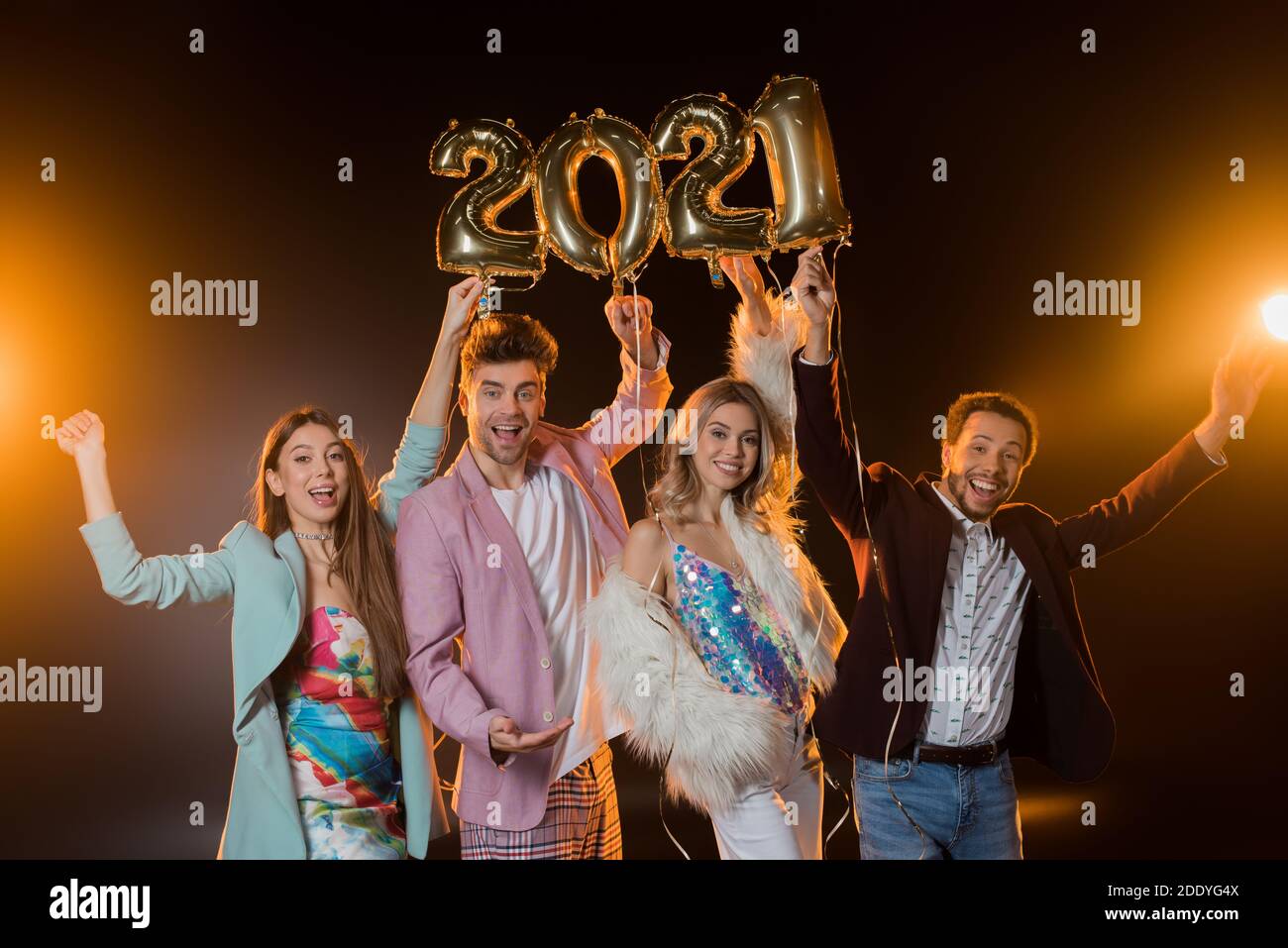 group of excited multicultural friends holding 2021 numbers balloons on ...