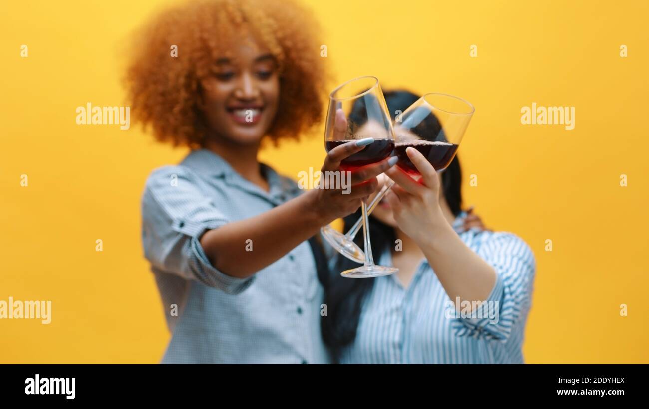 Cheers. Two young multiethnic friends, toasting with wine glasses. Best ...