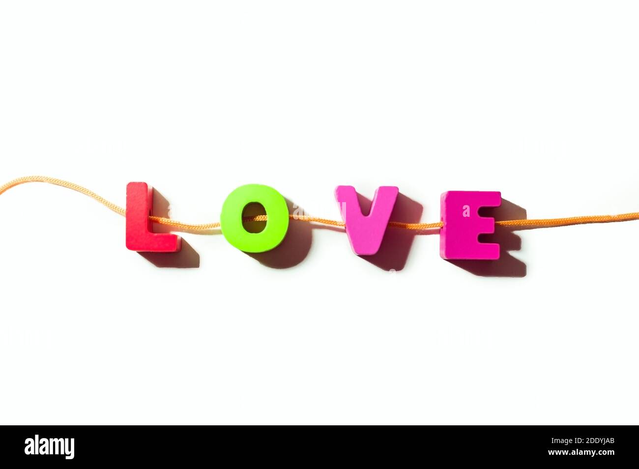 Word text Love spelling by colorful wooden letters with holes, strung ...