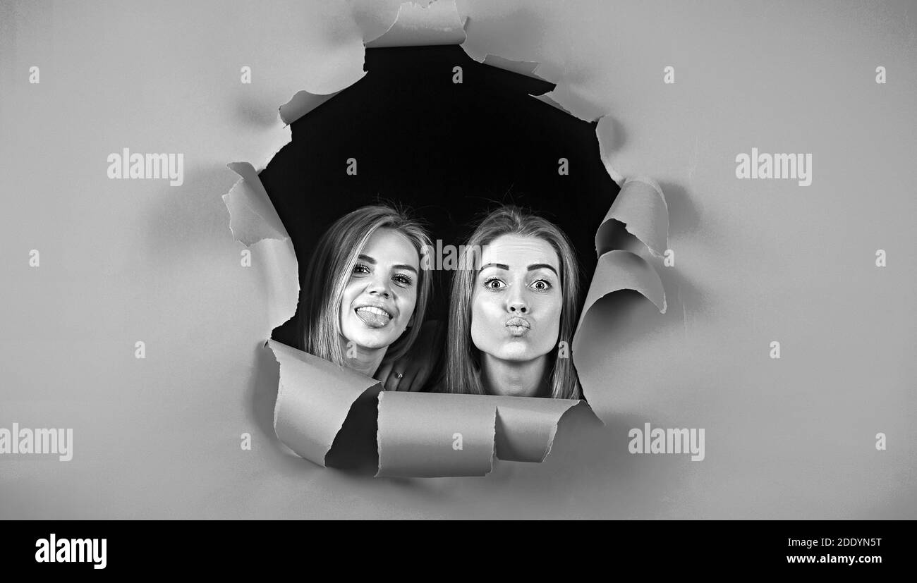 Young pretty women or girls breaking through a paper sheet Stock Photo ...