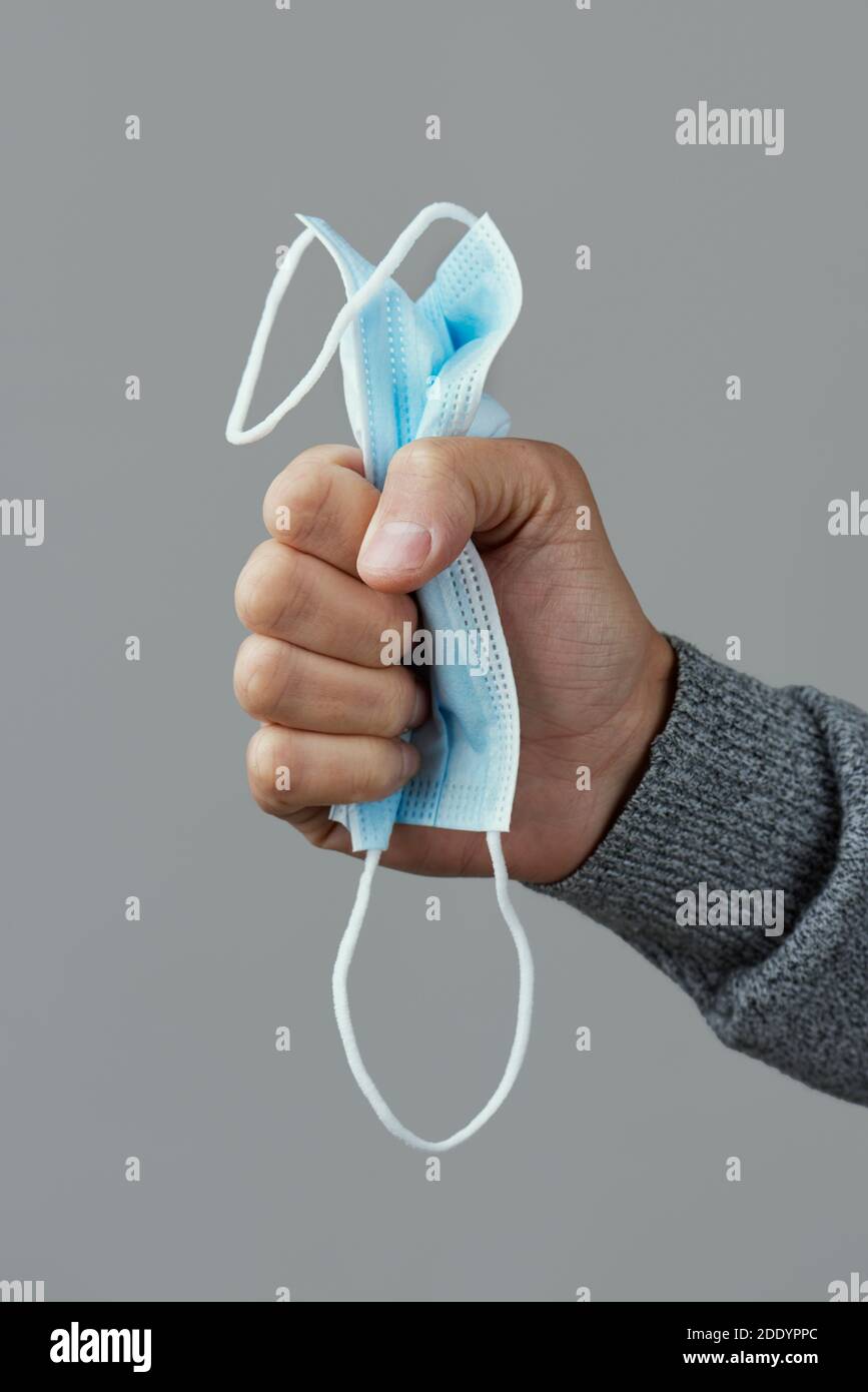 closeup of a caucasian man squeezing a face mask tightly in his hand ...