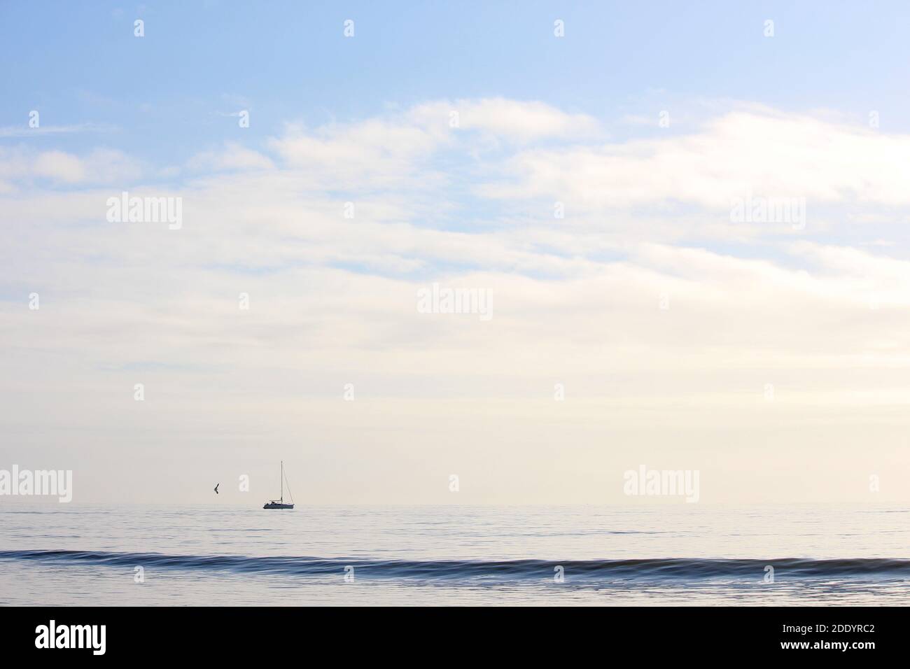 A photograph of a seascape with a yacht in the far distance on the ...