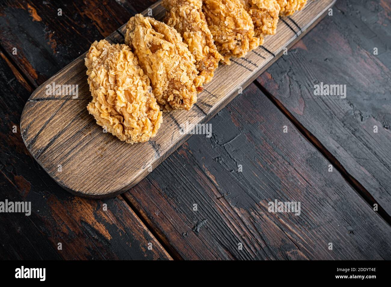 Fried chicken wings parts on old dark wooden table, top view, with copy ...