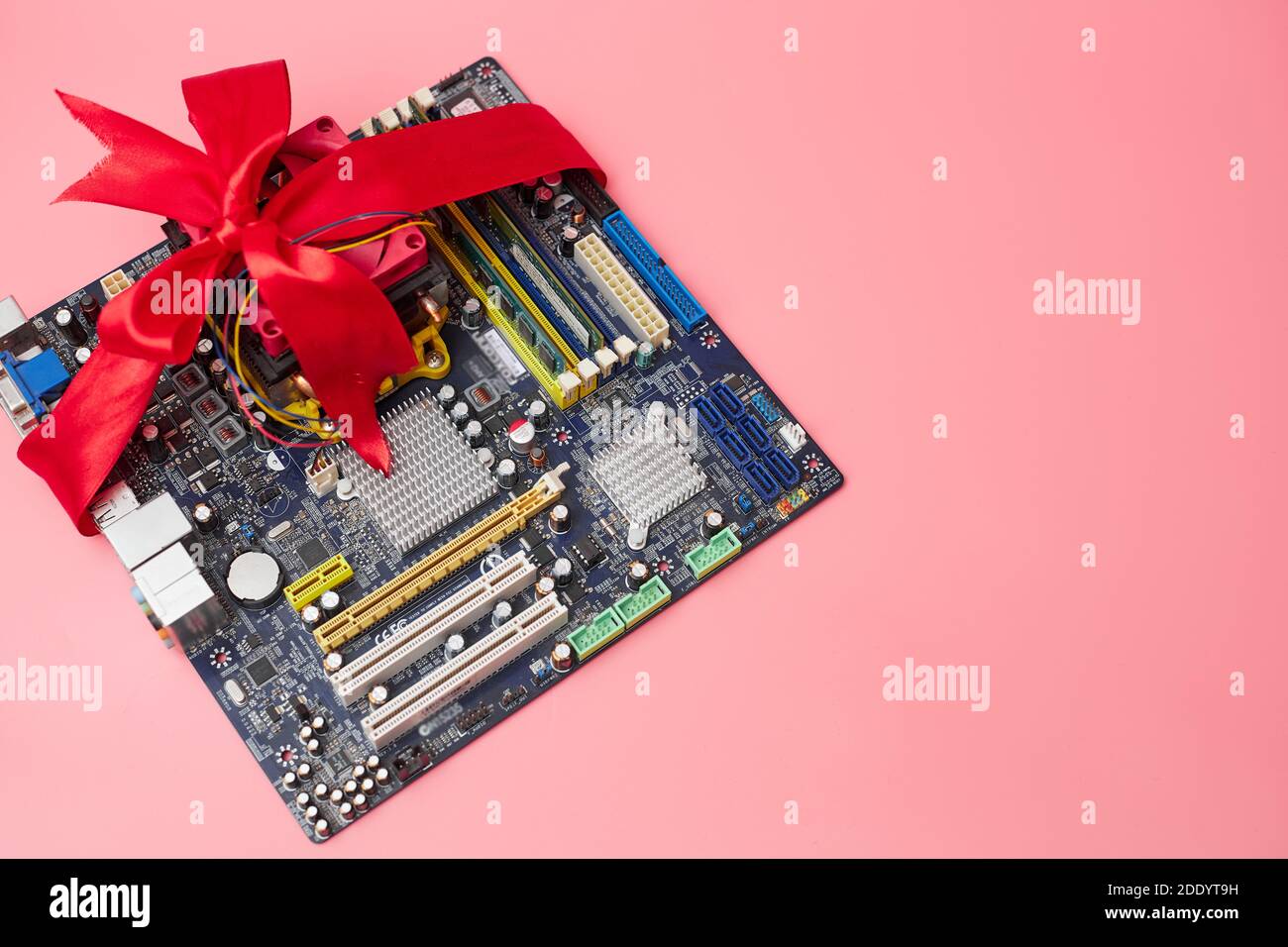sale of computer components, motherboard in red ribbon, on pink ...
