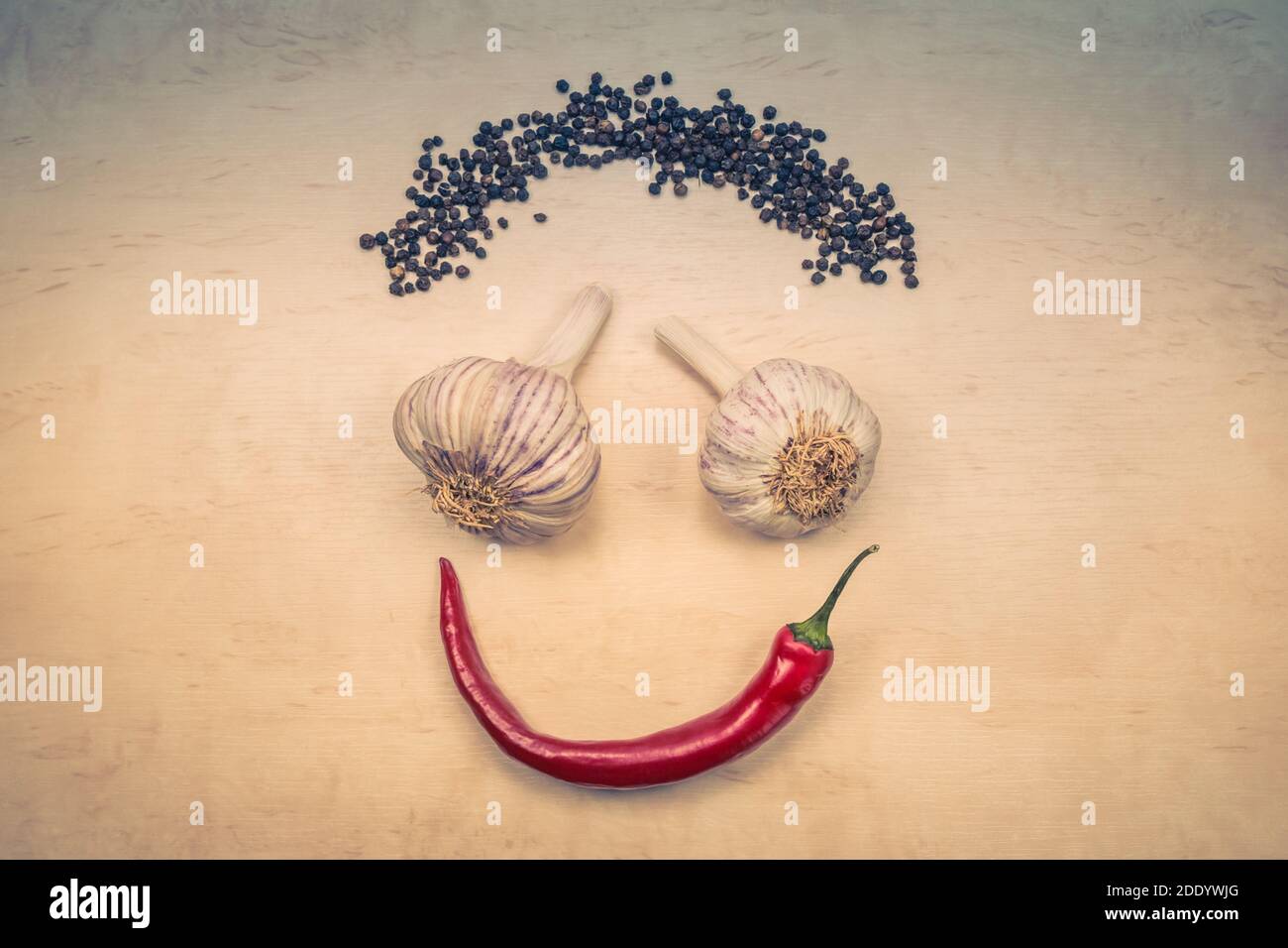 Smiley face of spices: garlic, hot chili and black pepper, wooden table ...