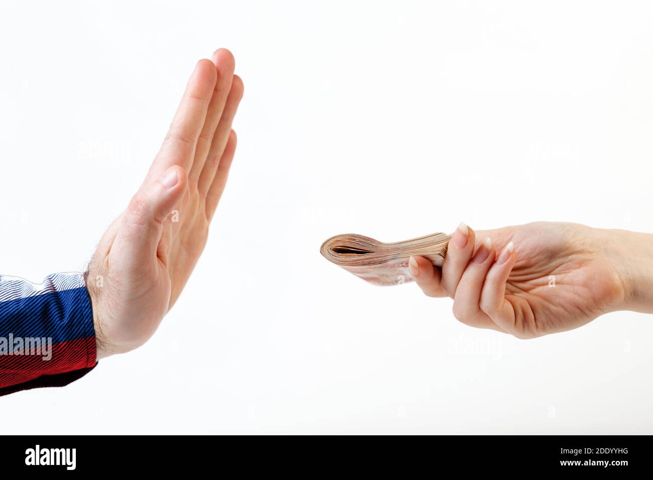 A woman's hand gives a bribe to a refusing man's hand in a shirt the ...