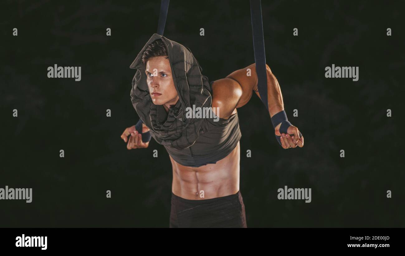Beautiful young acrobat makes pull-ups on ropes Stock Photo - Alamy