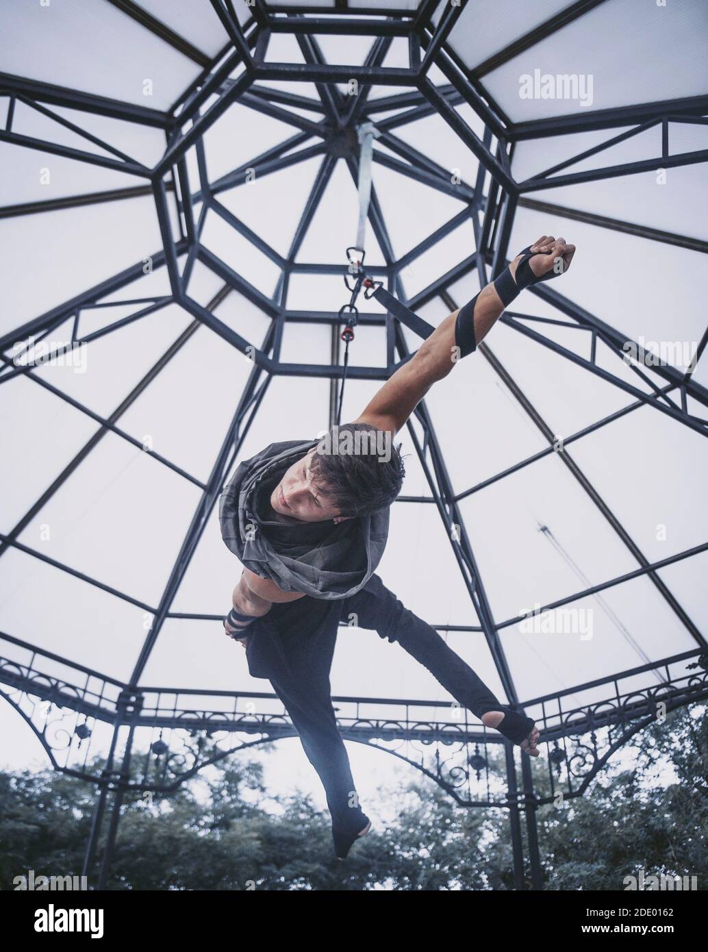 Difficult training of young athlete on strings above dome of light ...