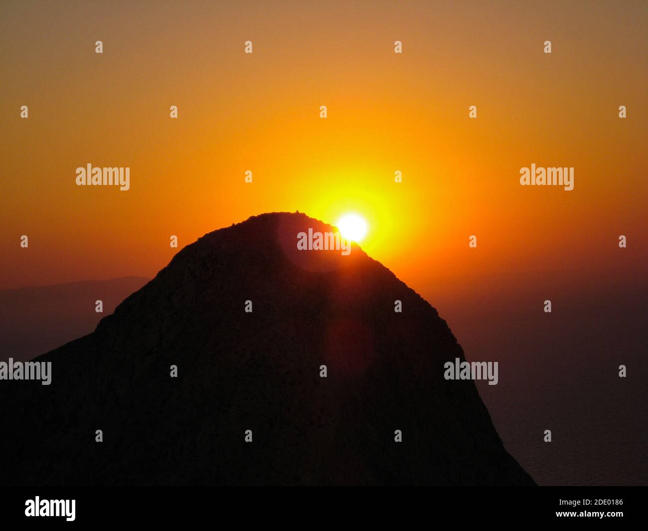 Sun rises behind the rock Stock Photo - Alamy