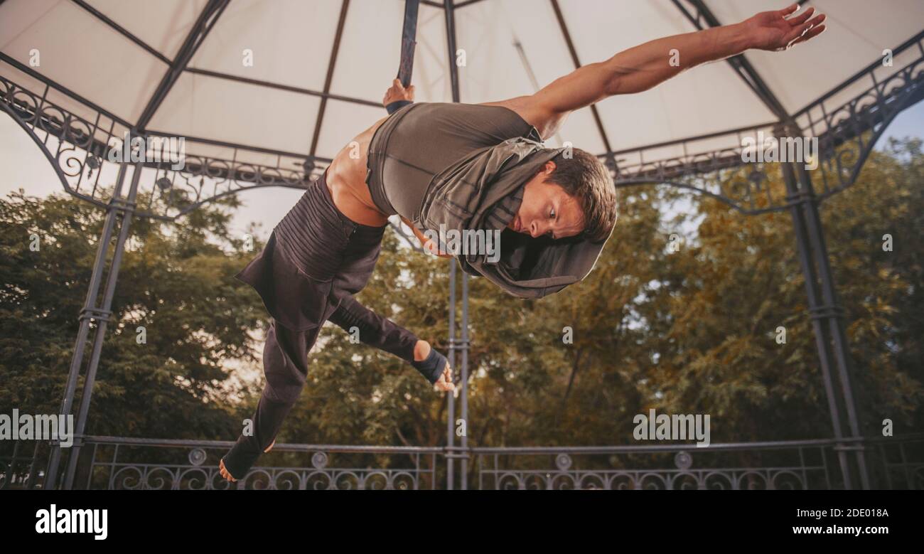 Difficult training of young athlete on strings above dome of light ...