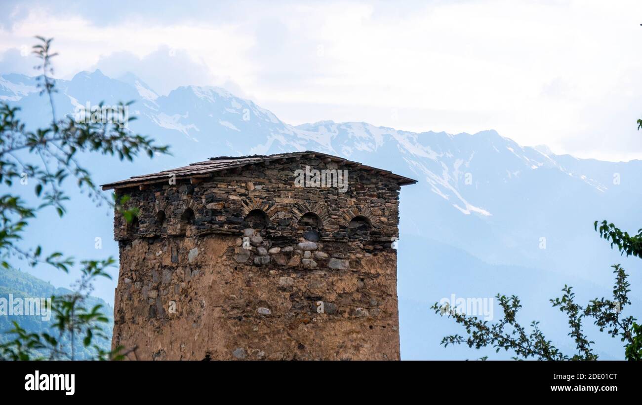 Far snow Georgian mountains behind the ancient tower Stock Photo - Alamy