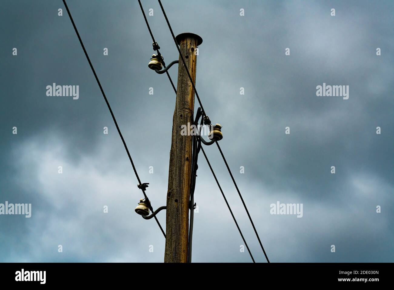 Old wooden post with power and phone lines on porcelain holders Stock ...