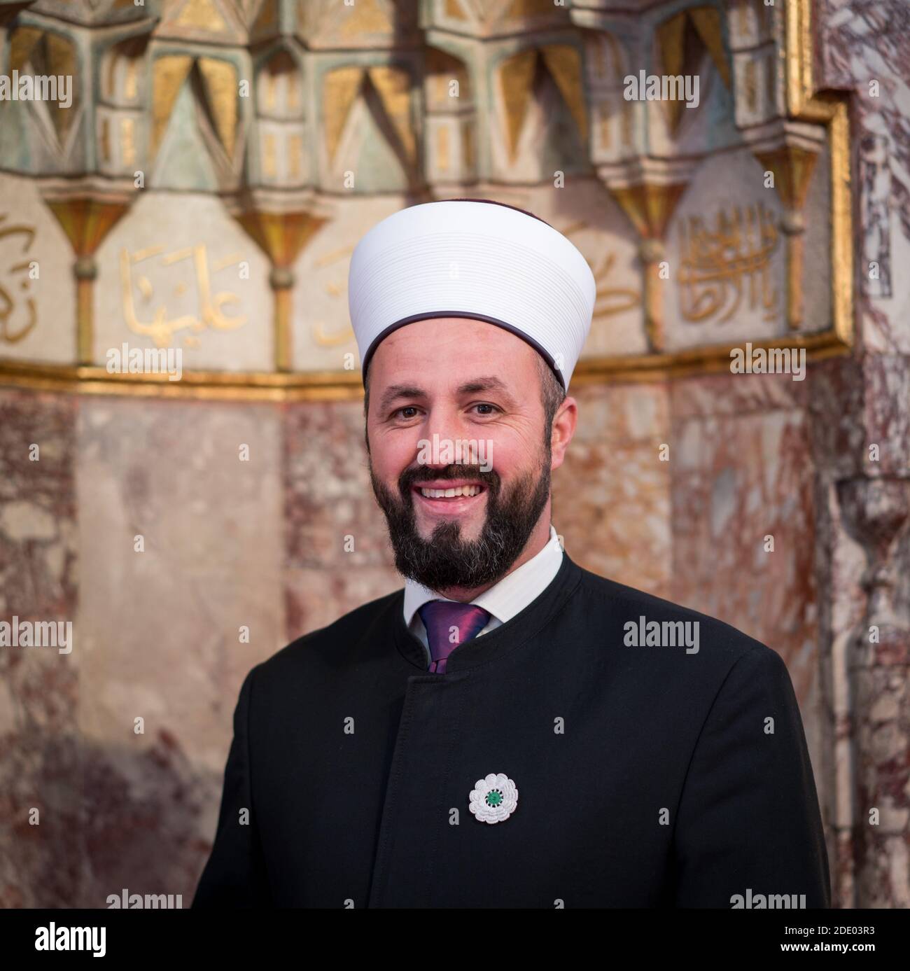 Emam in mosque with verses from Kuran on the wall Stock Photo - Alamy