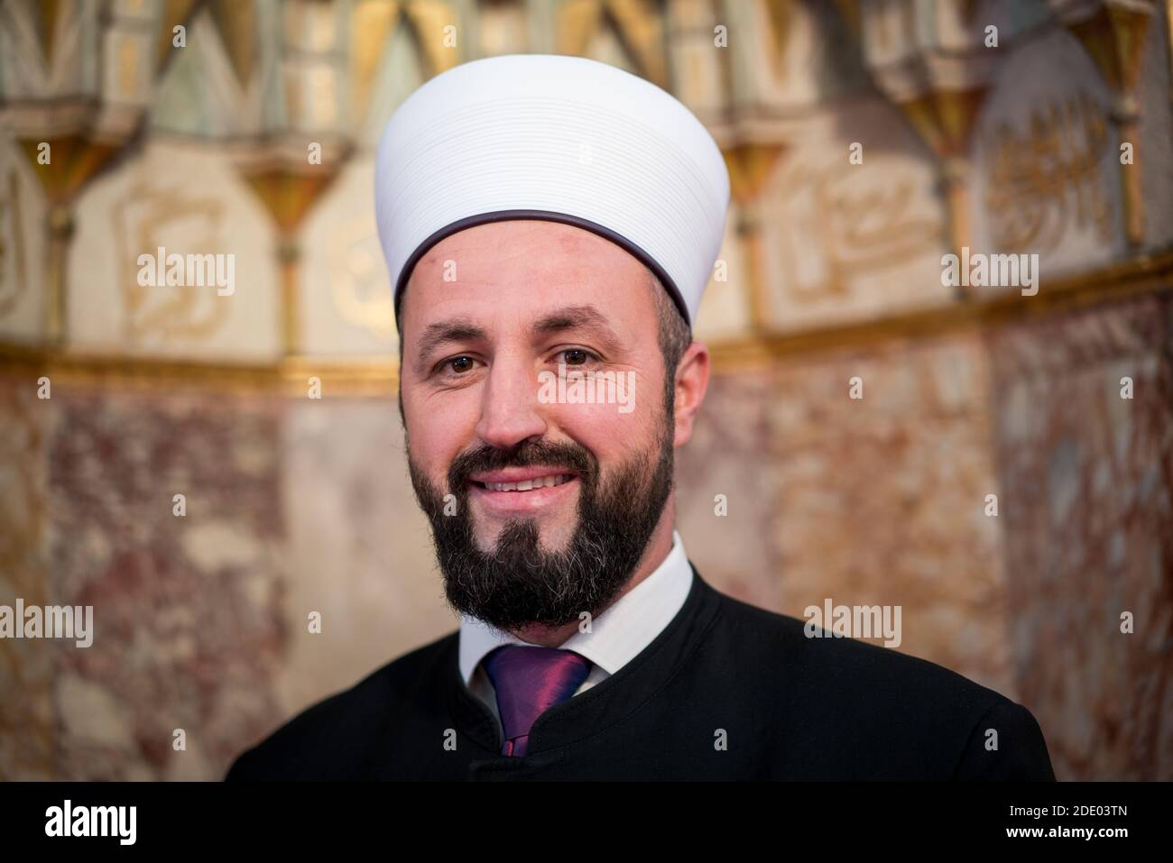 Emam in mosque with verses from Kuran on the wall Stock Photo - Alamy