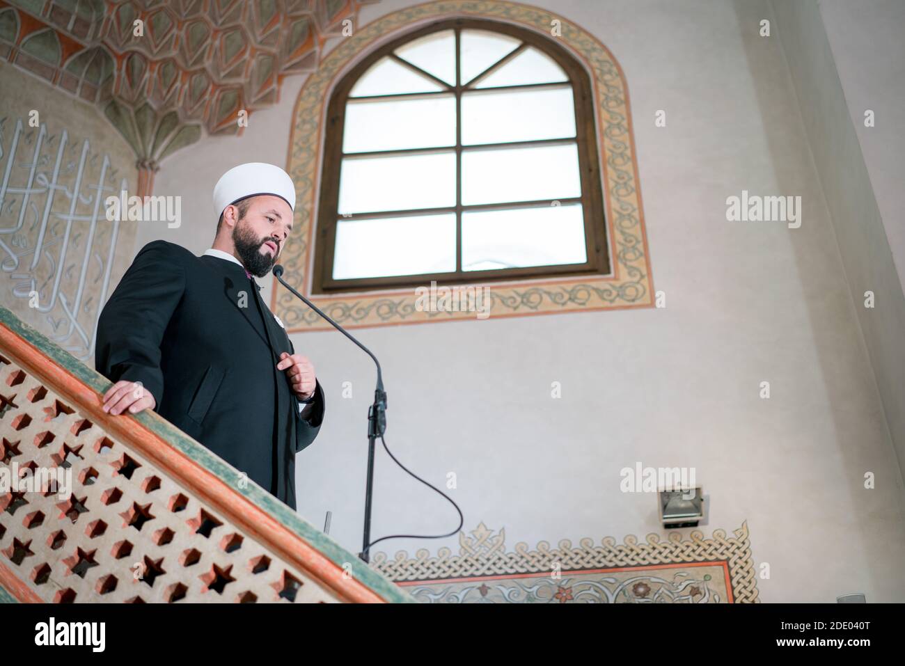 Emam in mosque with Arabic verses from Kuran on the wall Stock Photo ...