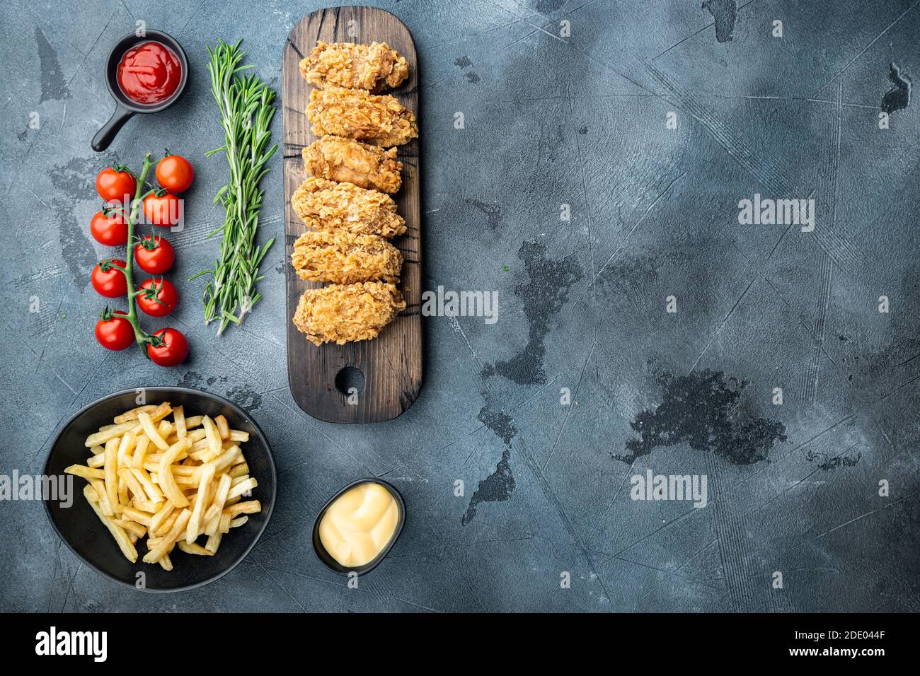 Fried chicken wings parts on grey background, flat lay, with copy space ...
