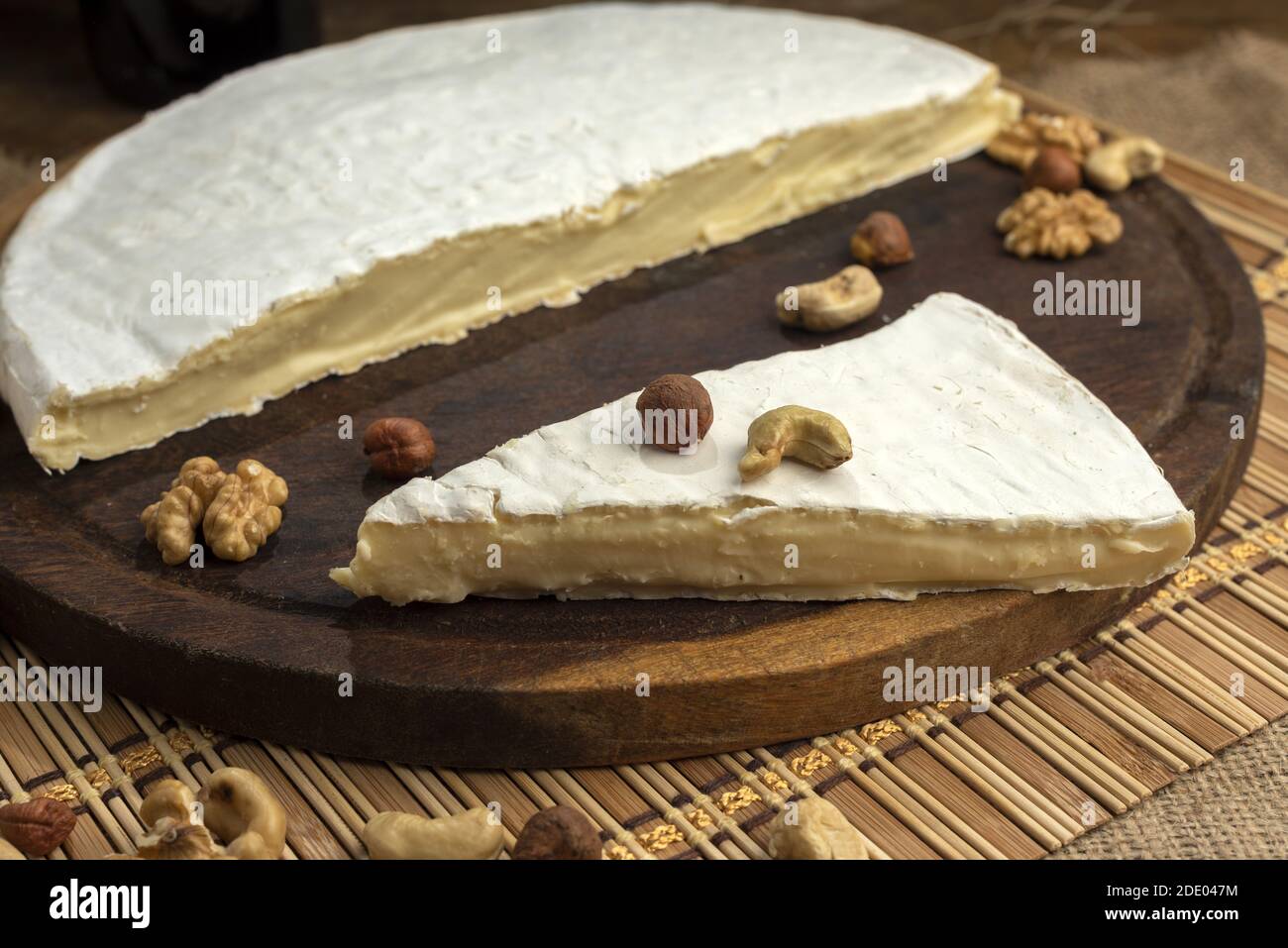 A closeup shot of a block of Camembert cheese on a wooden board with ...
