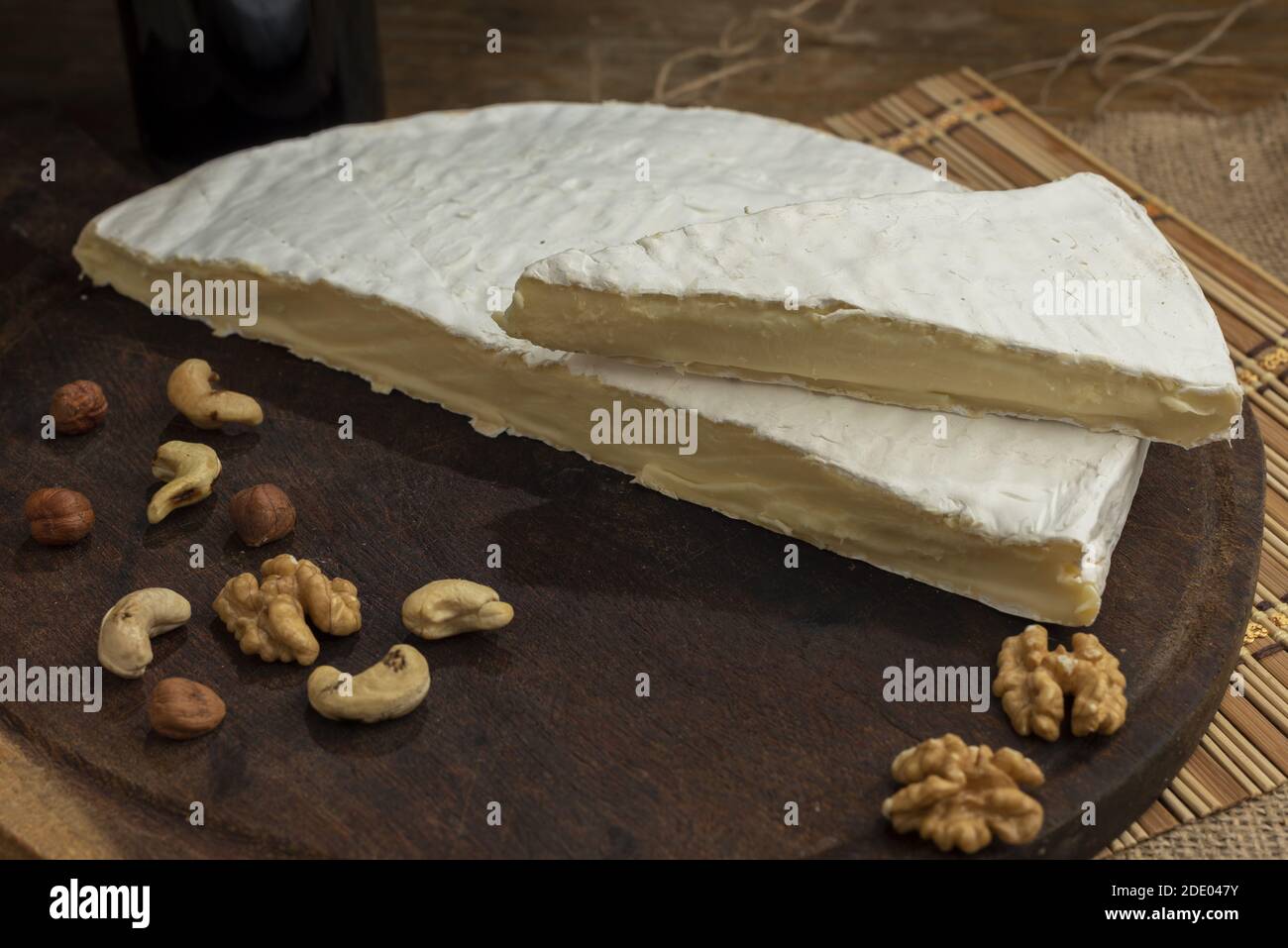 A closeup shot of a block of Camembert cheese on a wooden board with ...
