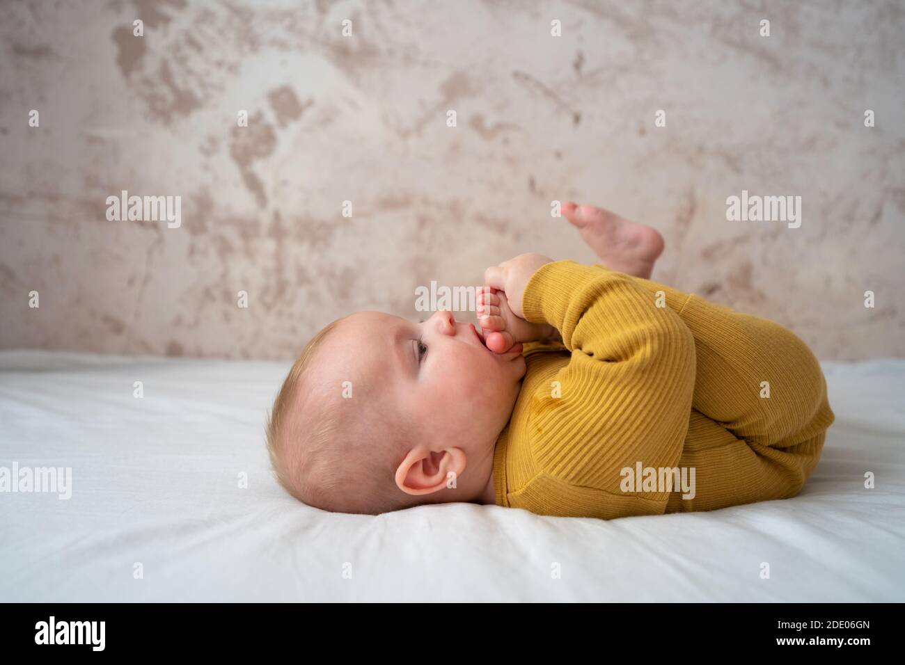 Cute baby boy with foot in his mouth, tasting toes Stock Photo - Alamy