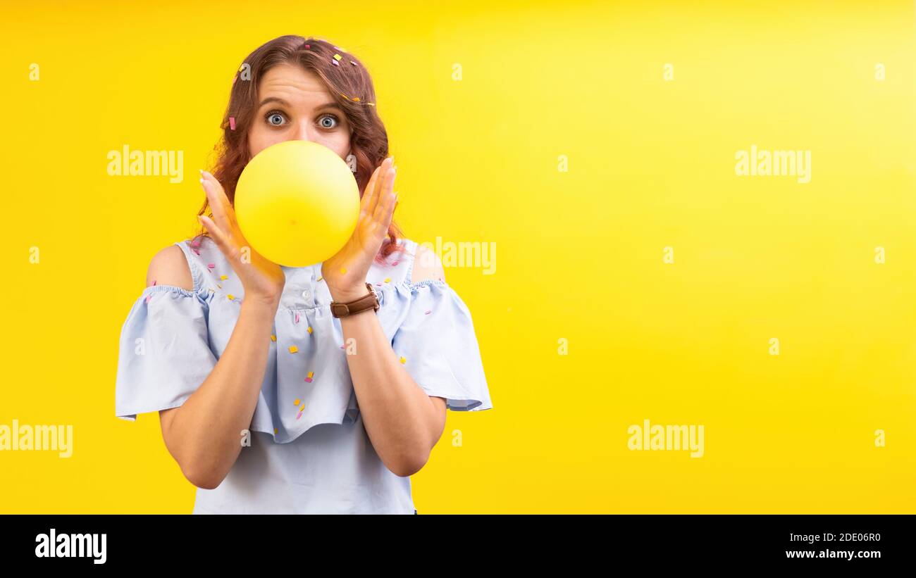 Surprised caucasian woman with a balloon between two hands, covering ...
