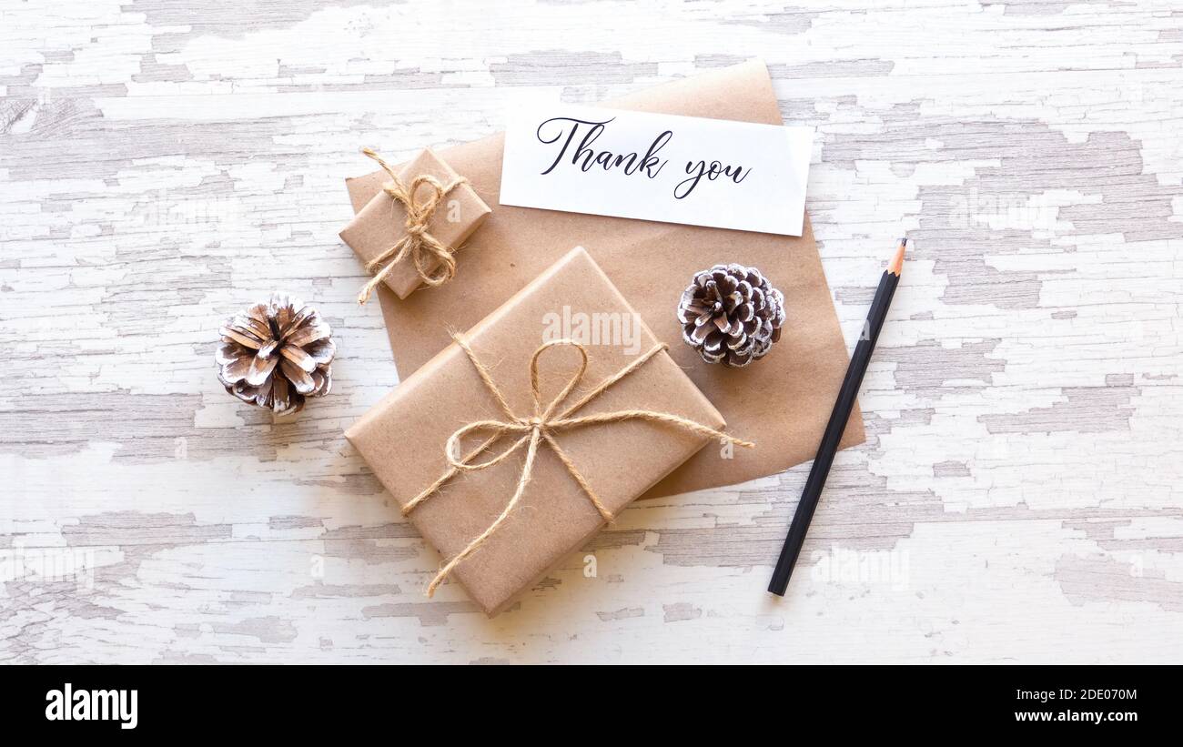 Gift boxes, fir cones, note with a message and a pencil. White ...