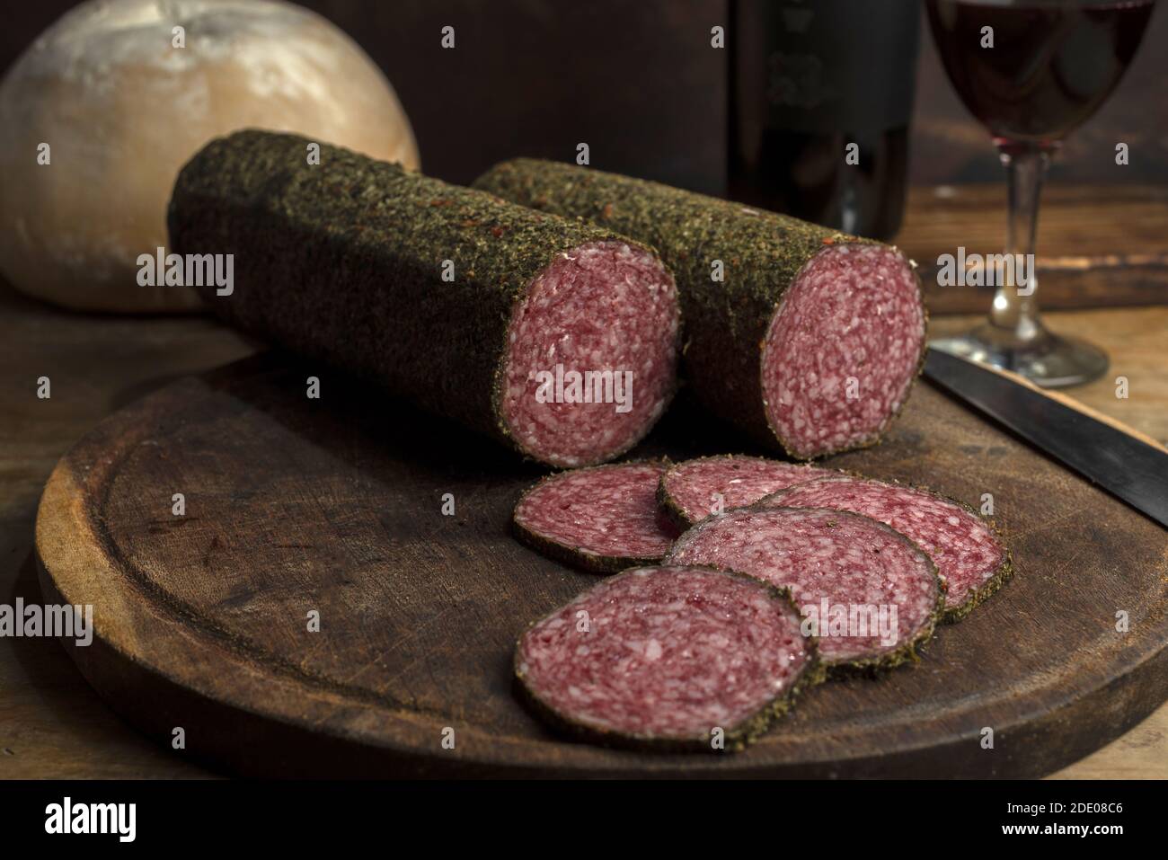 A closeup shot of rolls of smoked salami meat on a wooden board Stock ...