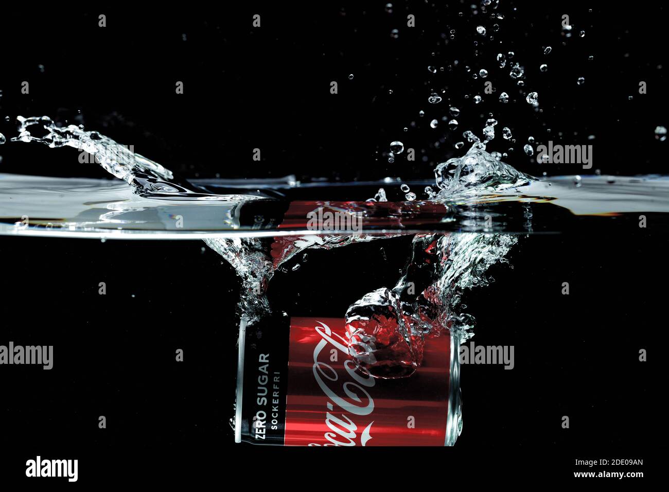Close up view of coca falling in water on black background. Gorgeous ...