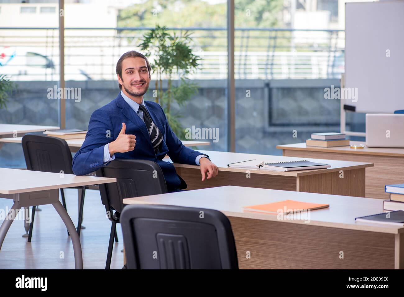 Young teacher in suit in the classroom Stock Photo - Alamy