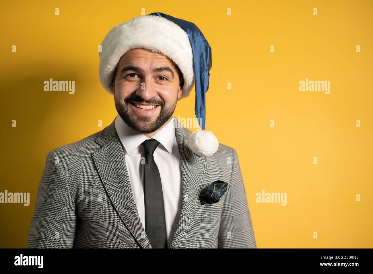 A happily smiling employee or flight manager put on a Santa hat and is ...