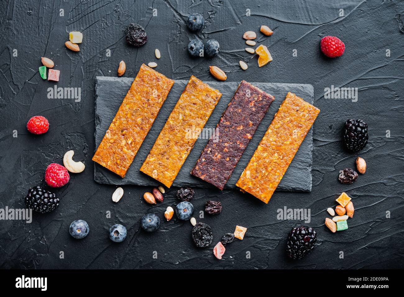 Fruit berry and nut energy bars, healthy snack, flat lay,on black ...