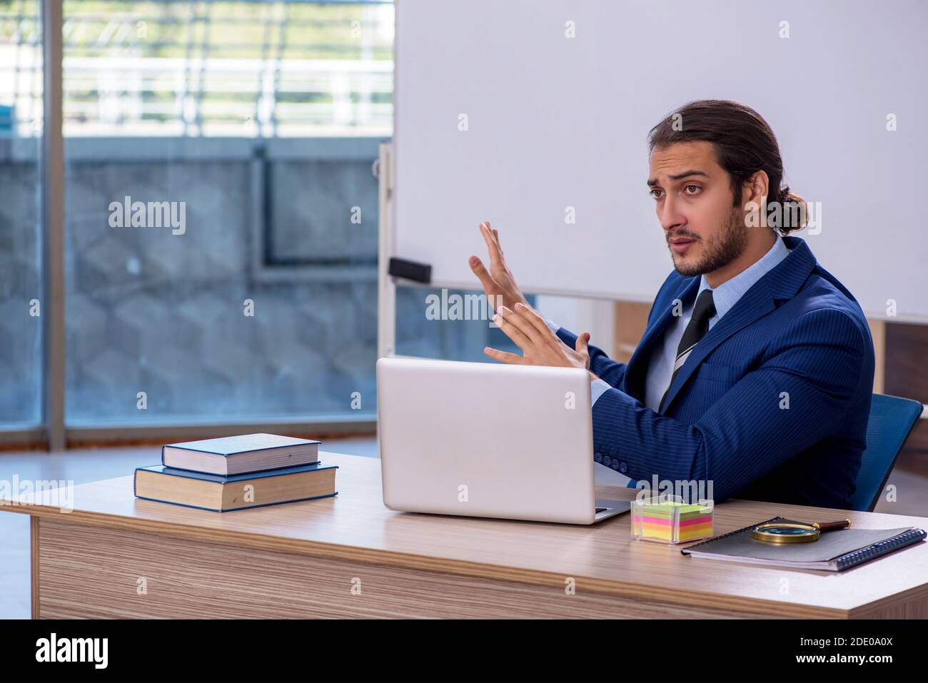 Young teacher in suit in the classroom Stock Photo - Alamy