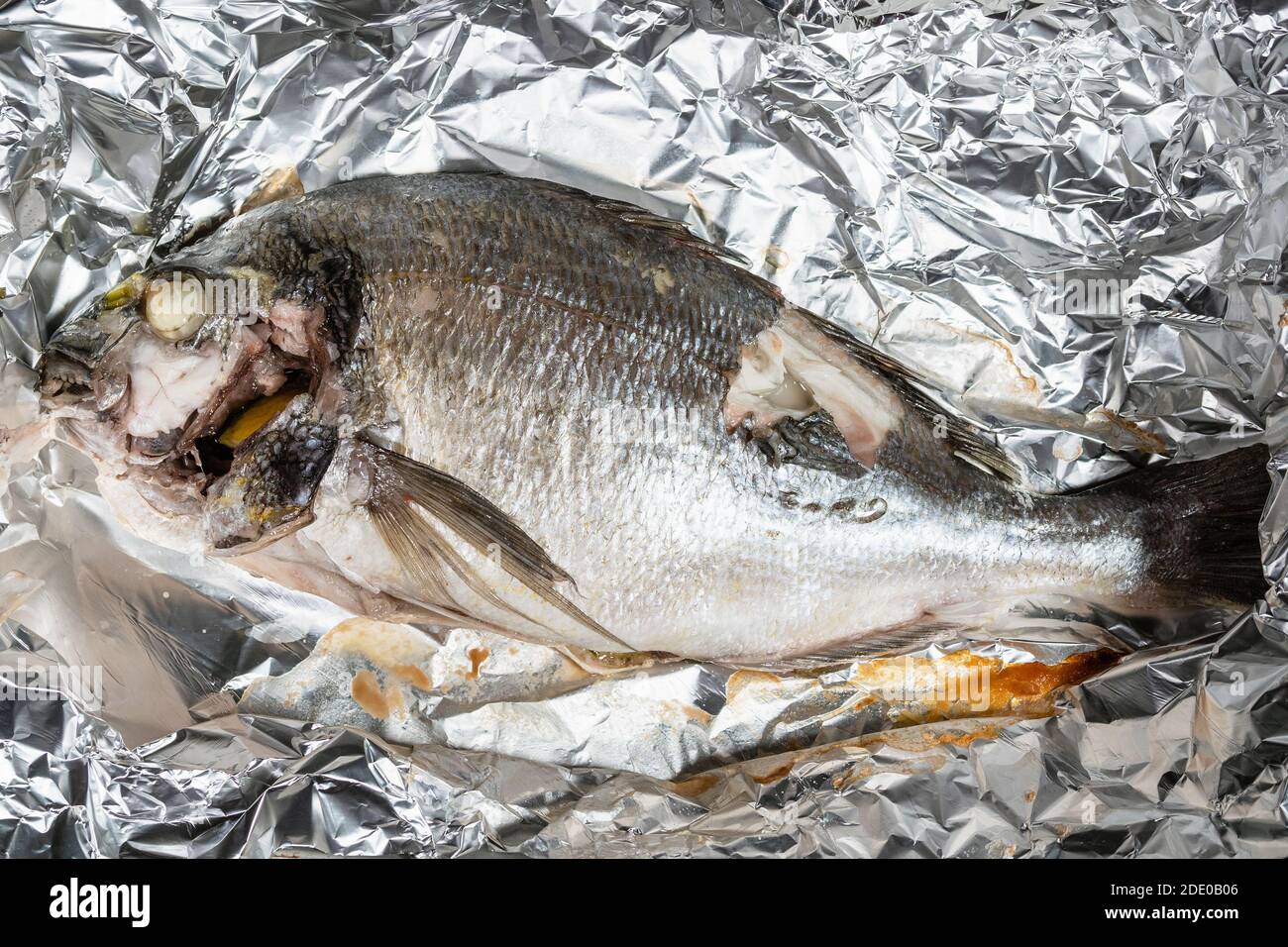 open cooked Orata fish baked in foil Stock Photo - Alamy