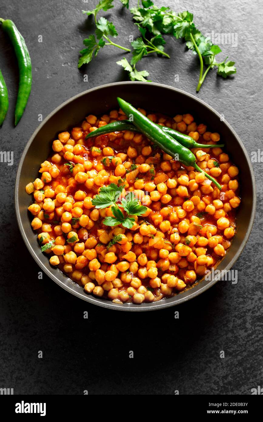Crispy roasted chickpeas. Indian style dish over black stone background ...