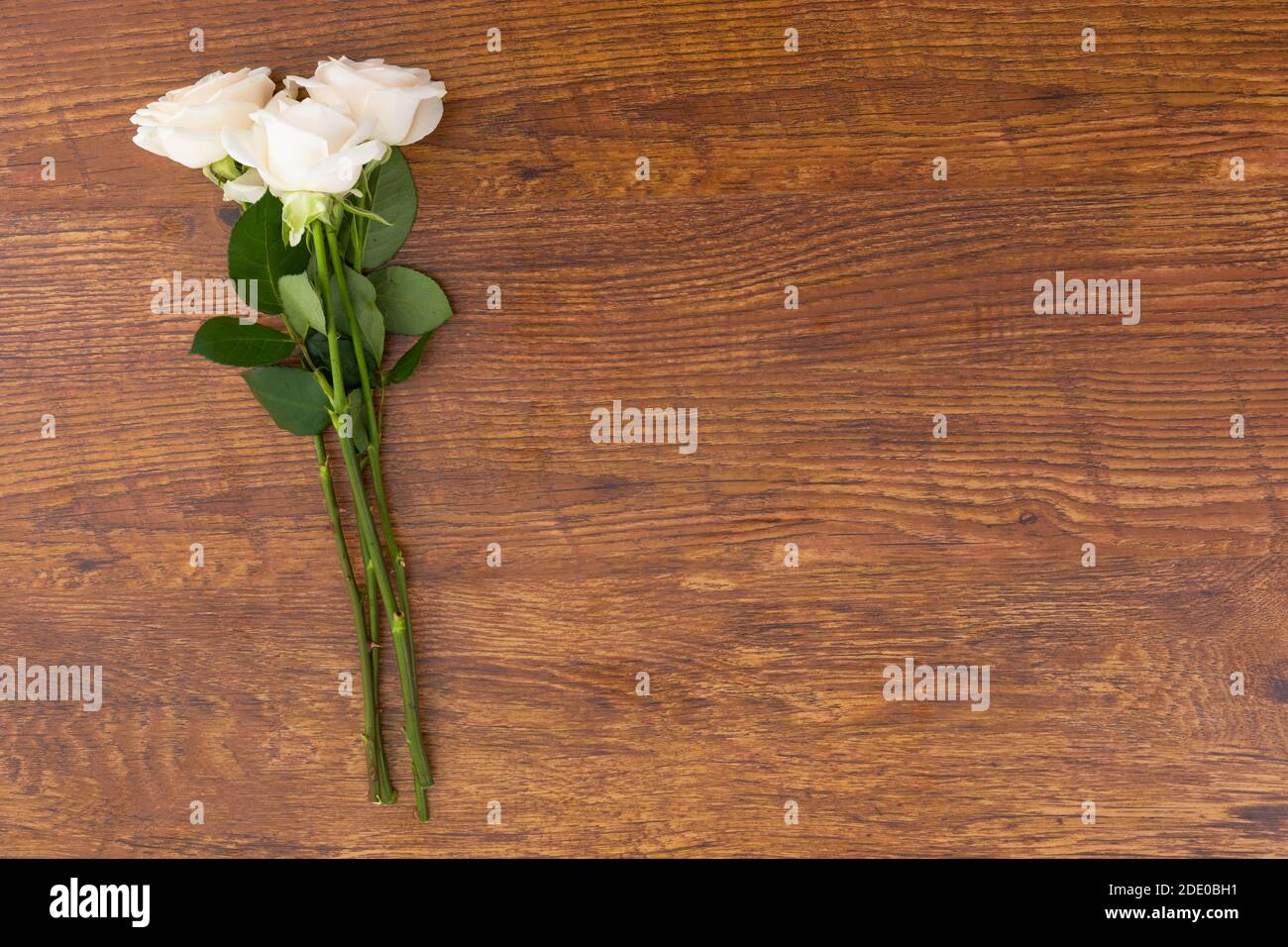 Bunch of white roses lying on wooden background Stock Photo - Alamy