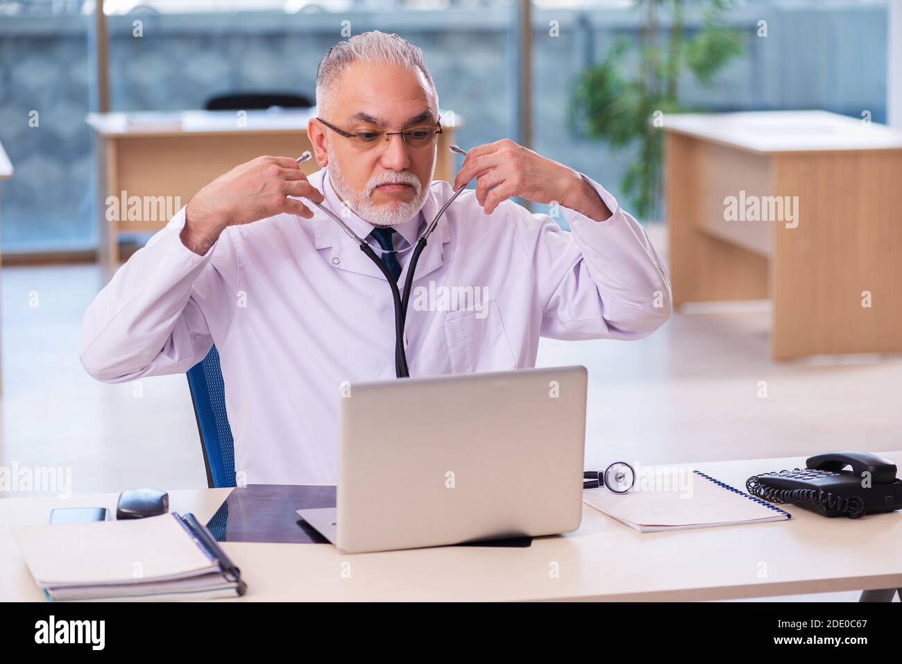 Old doctor working in the clinic Stock Photo - Alamy