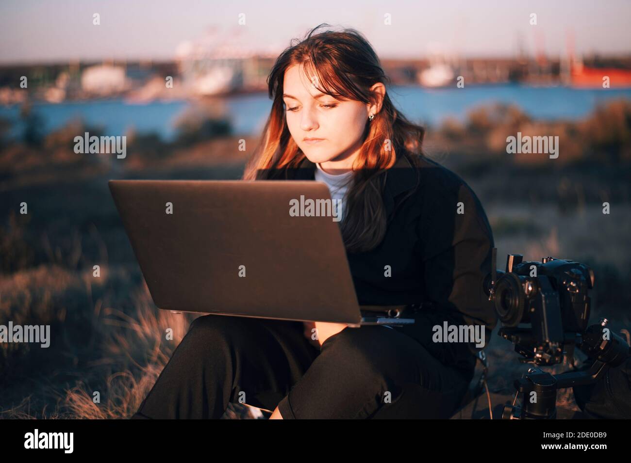 Pretty girl with laptop and camera on a hills Stock Photo - Alamy