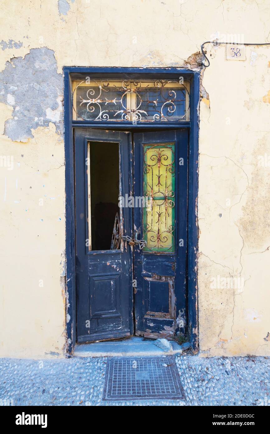 Old distressed blue painted wooden doors with ornate ironwork on facade ...