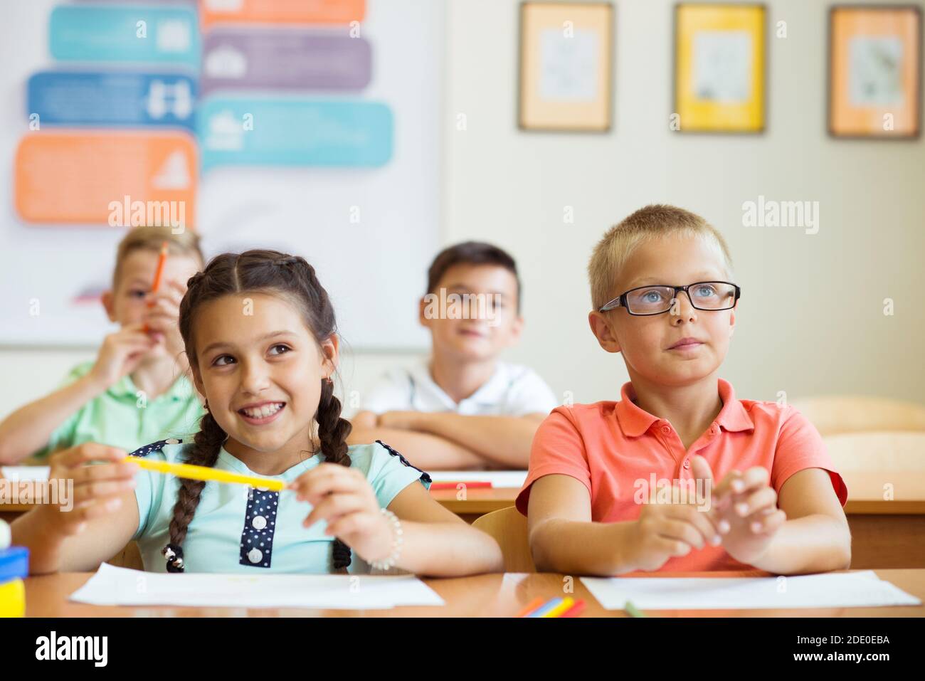 Happy schoolchildren studing and answer questions in classroom during a ...